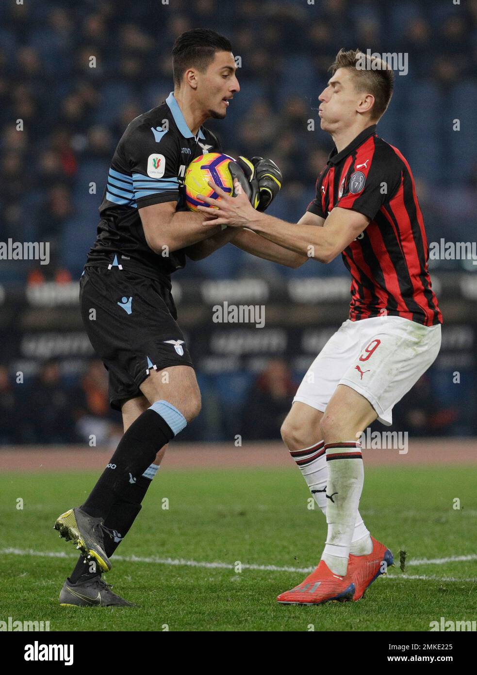Lazio goalkeeper Thomas Strakosha stops a ball flanked by AC Milan's ...