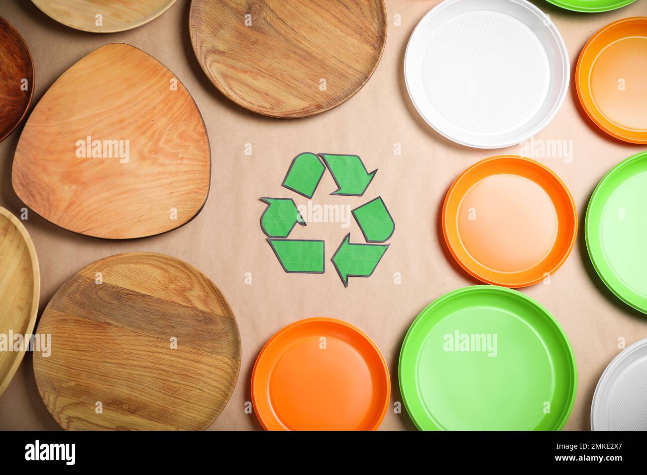 Recycling symbol, plastic and wooden plates on beige background, flat ...