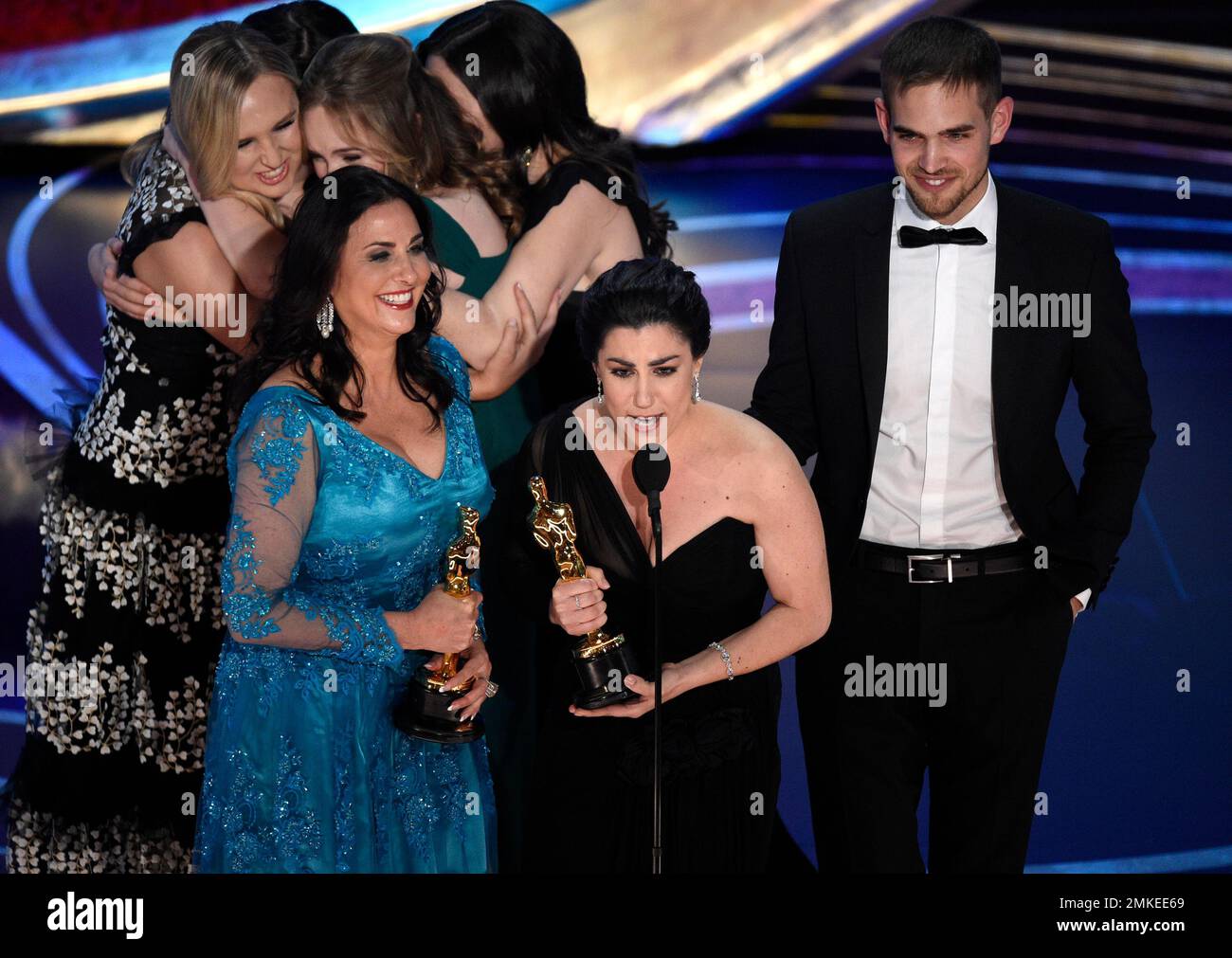 Melissa Berton, center left, and Rayka Zehtabchi accept the award for ...