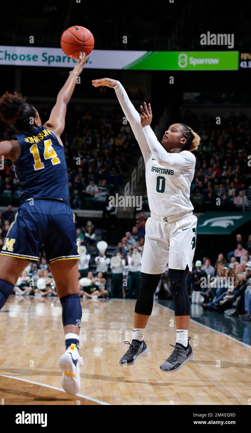 Michigan State's Shay Colley, right, shoots against Michigan's Akienreh ...