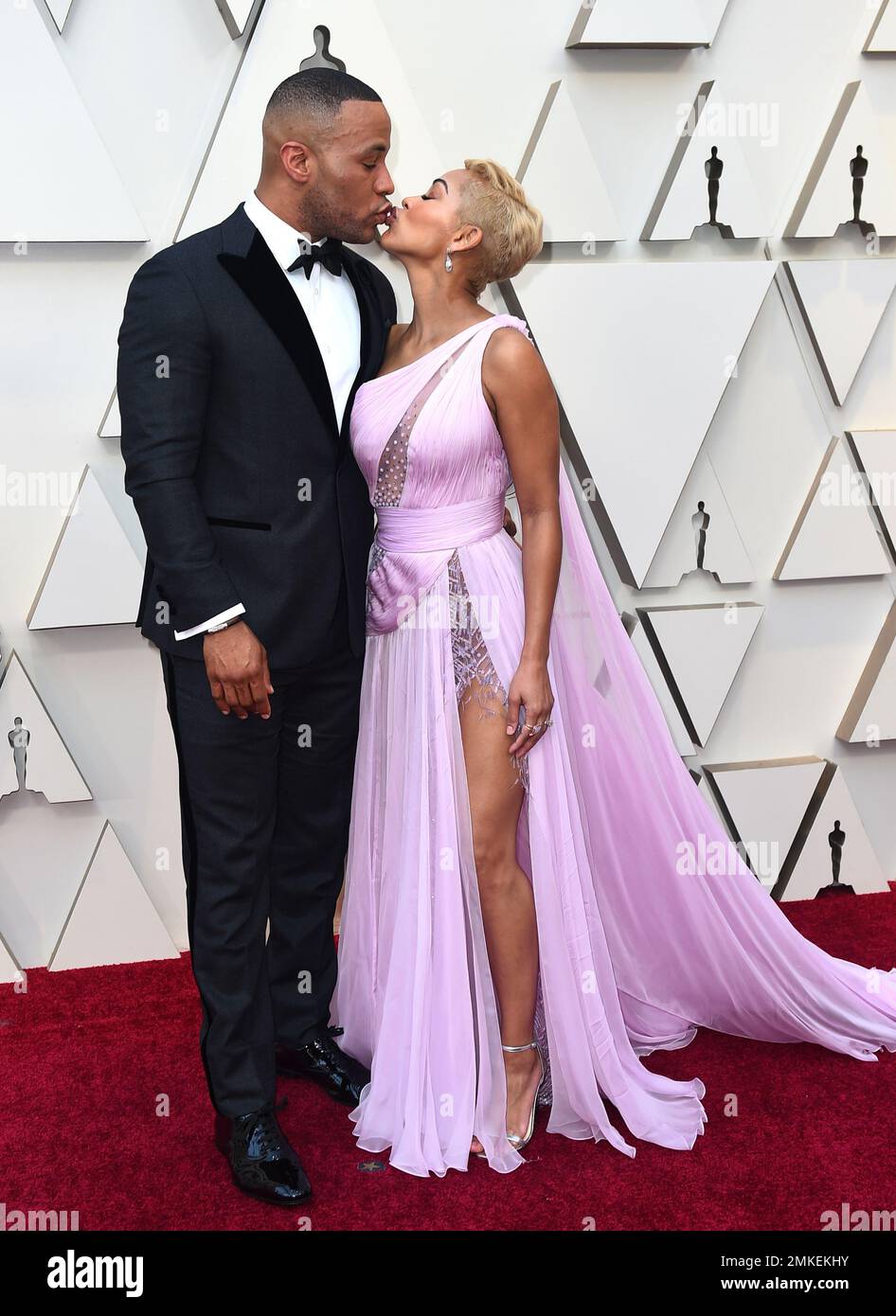 DeVon Franklin, left, and Meagan Good kiss as they arrive at the Oscars ...