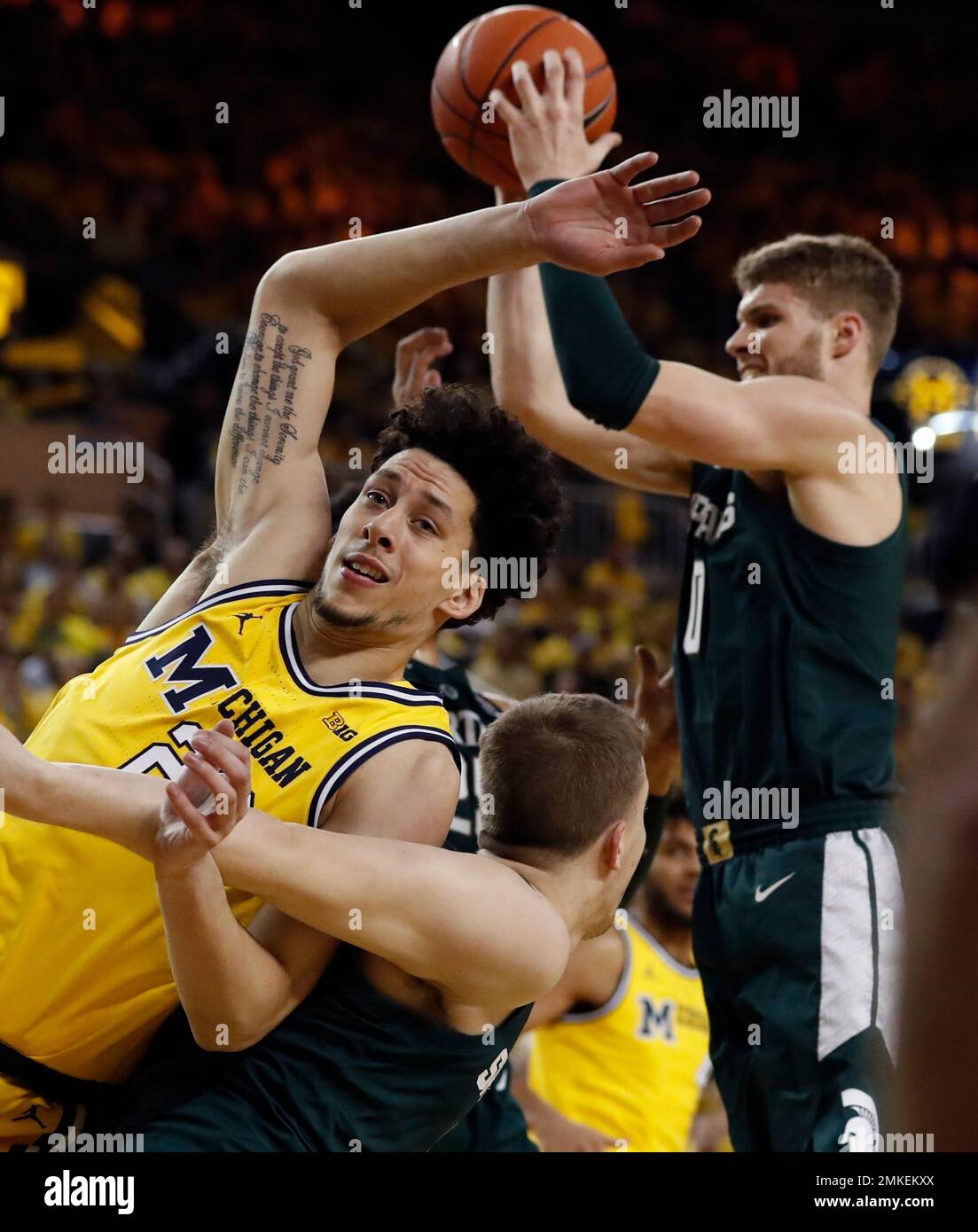 Michigan State forward Kyle Ahrens (0) grabs a rebound next to Michigan ...
