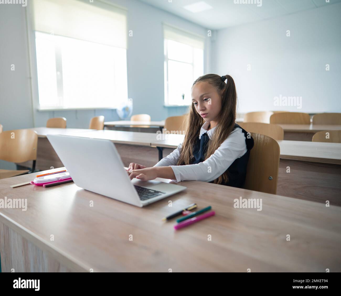 Caucasian girl studying on a laptop in a classroom Stock Photo - Alamy