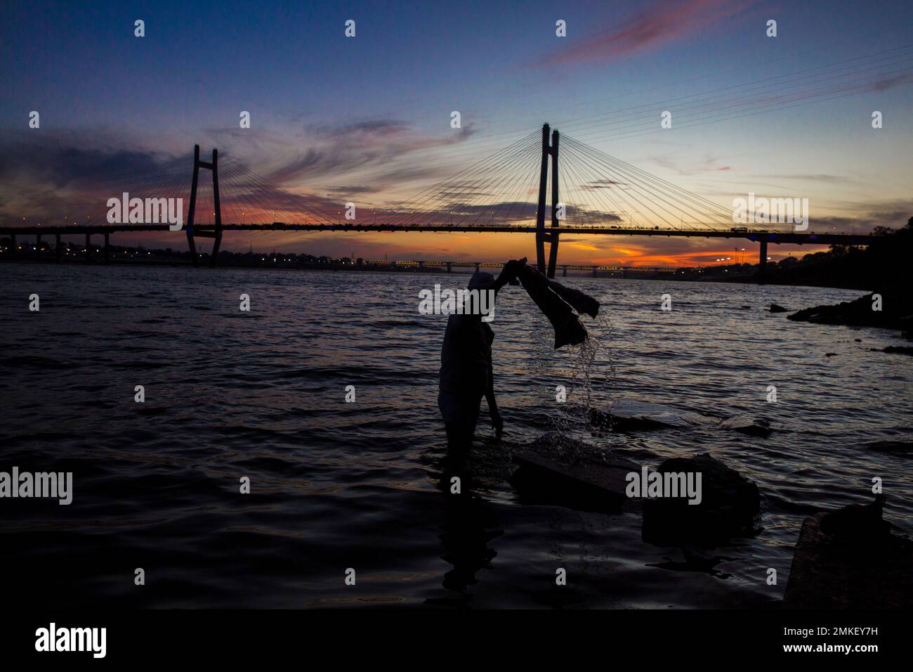 An Indian Dhobi, or washerman, washes clothes on the banks of the River ...