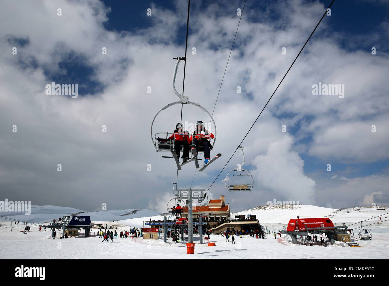 A couple rides a ski lift heading up a hill at the Faraya-Mzaar ski ...