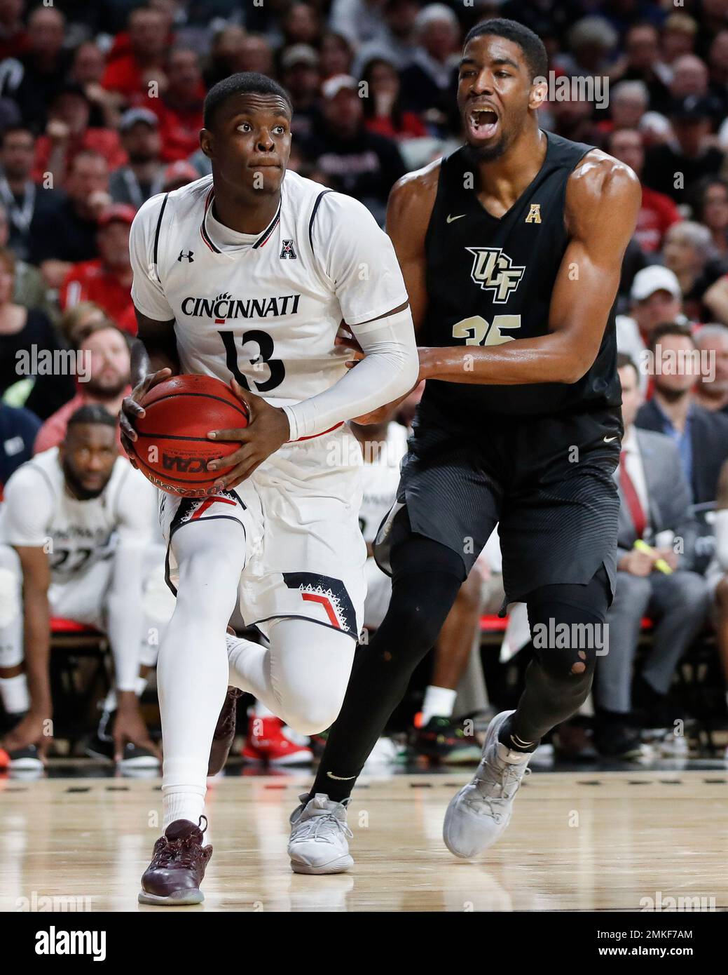 Cincinnati's Tre Scott (13) drives past Central Florida's Collin Smith ...