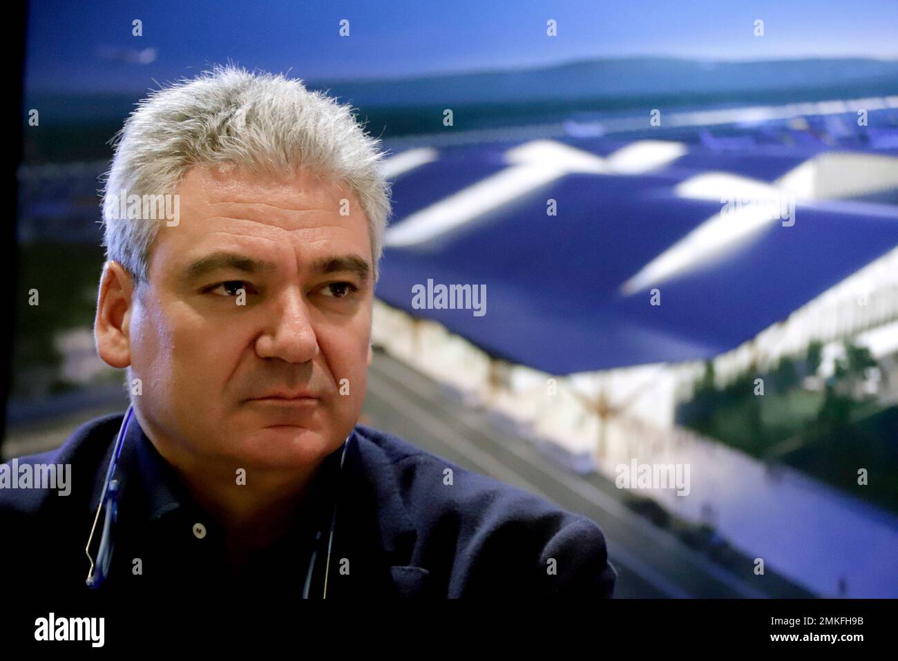 Architect Luis Vidal sits in front of a rendering of his proposed ...