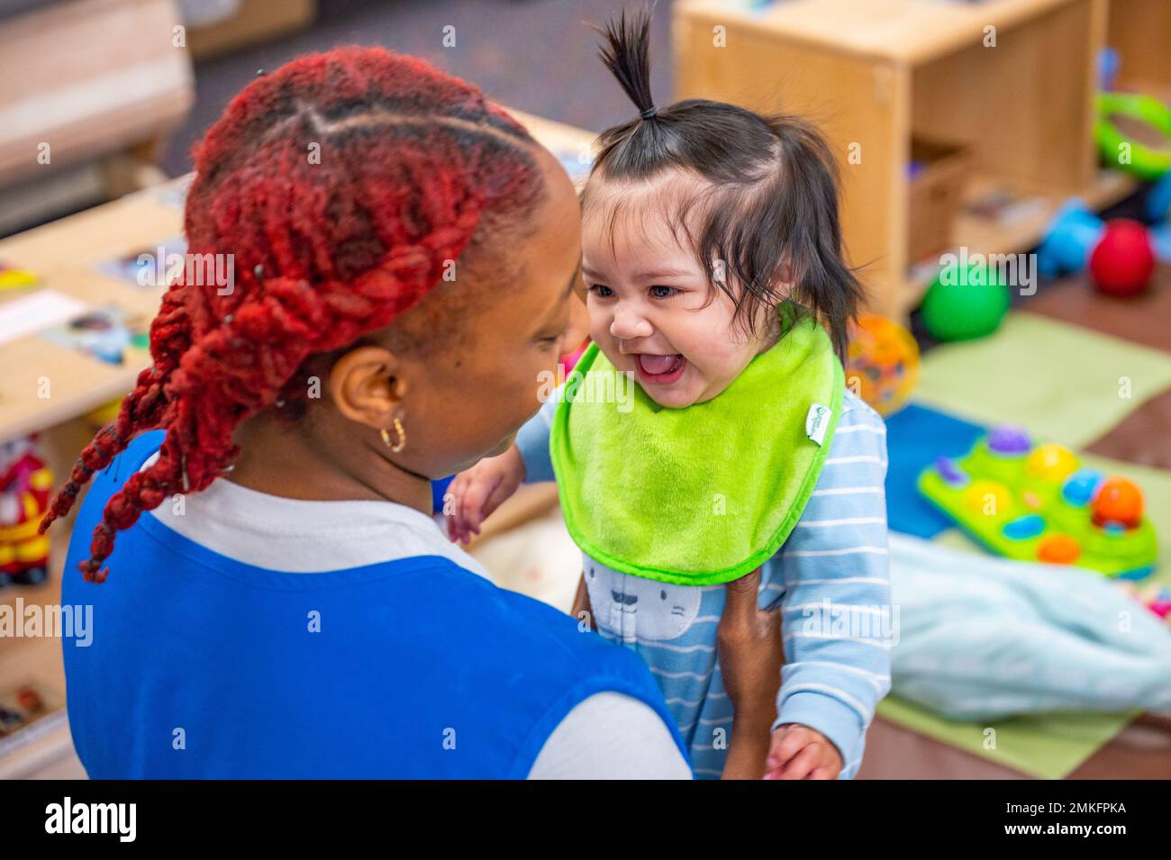 A worker from the Malmstrom Child Development Center, holds a child ...