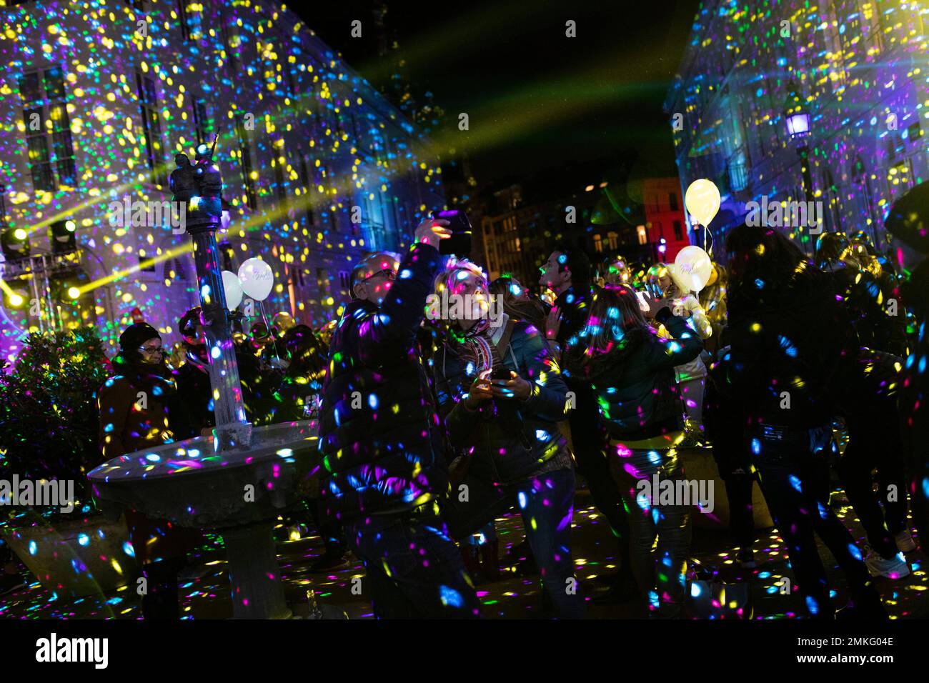 People watch and take photographs of a light installation during the ...