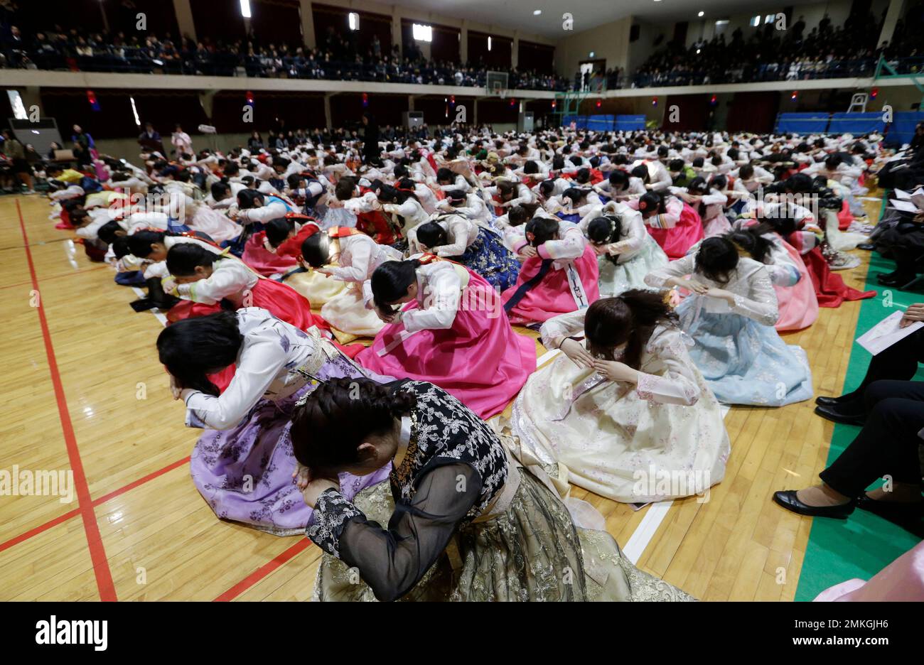 South Korean seniors clad in traditional attire bow during a joint ...