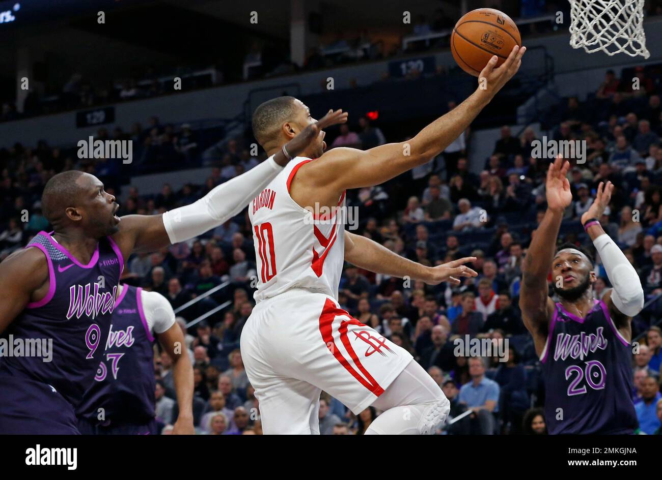 Houston Rockets' Eric Gordon, center, drives for a layup between ...