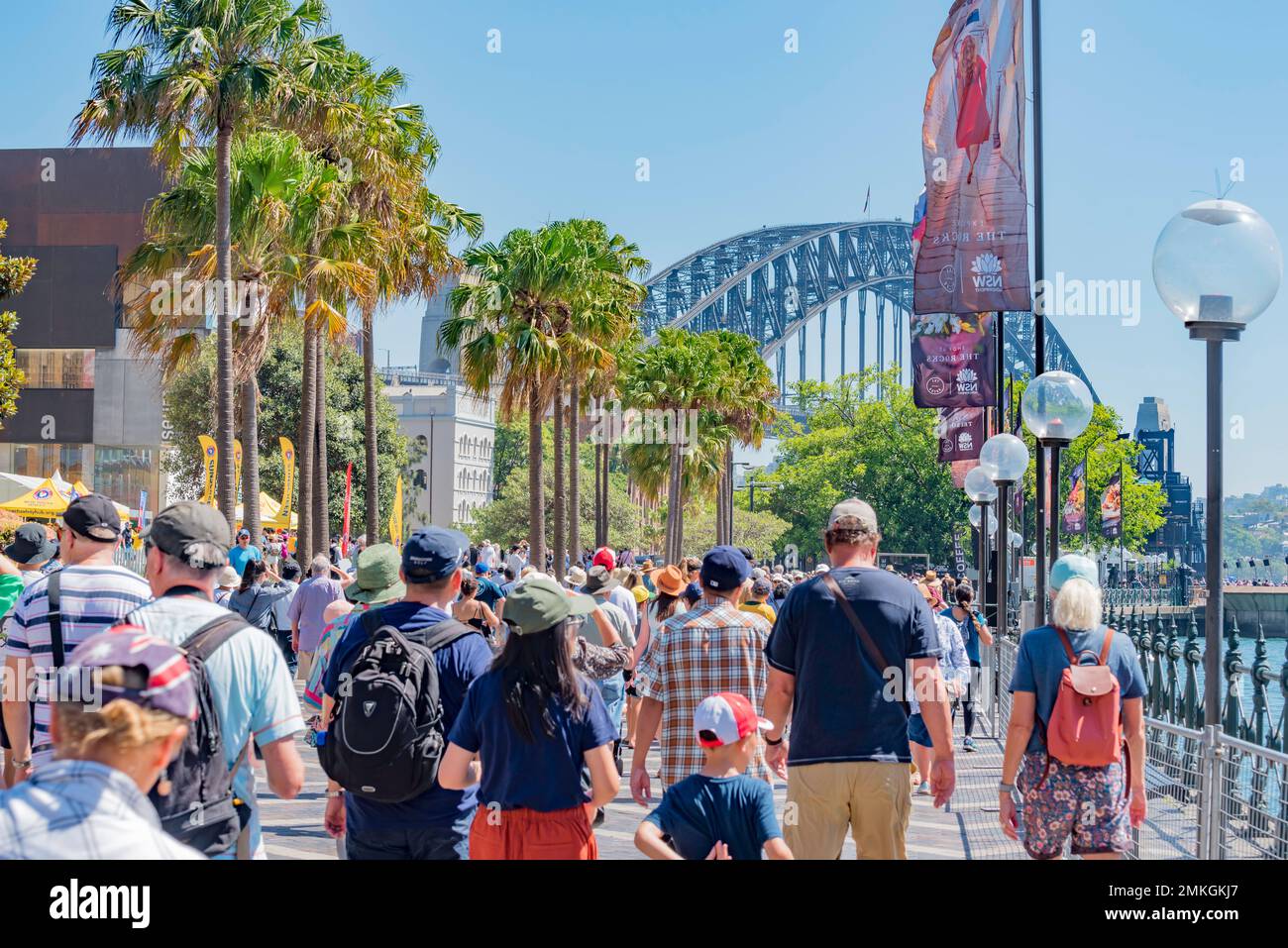Crowds of people moving in Circular Quay with the Sydney Harbour Bridge ...