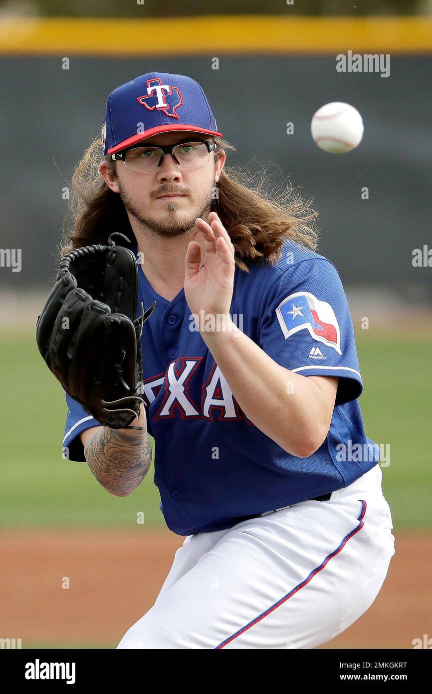 Texas Rangers pitcher Zac Curtis fields a ball during spring training ...