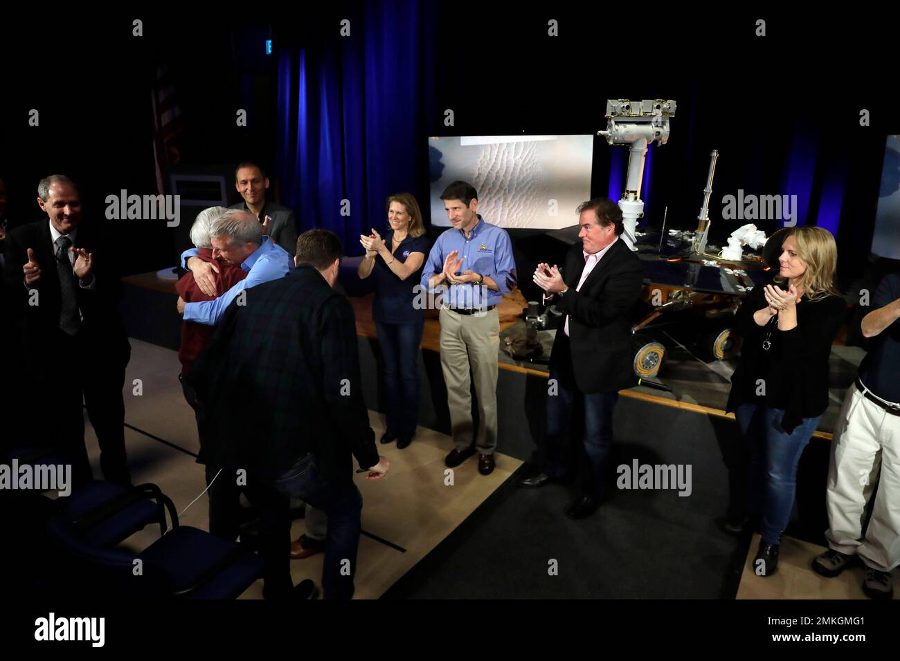 Scientists and other NASA officials applaud and embrace after a mission ...