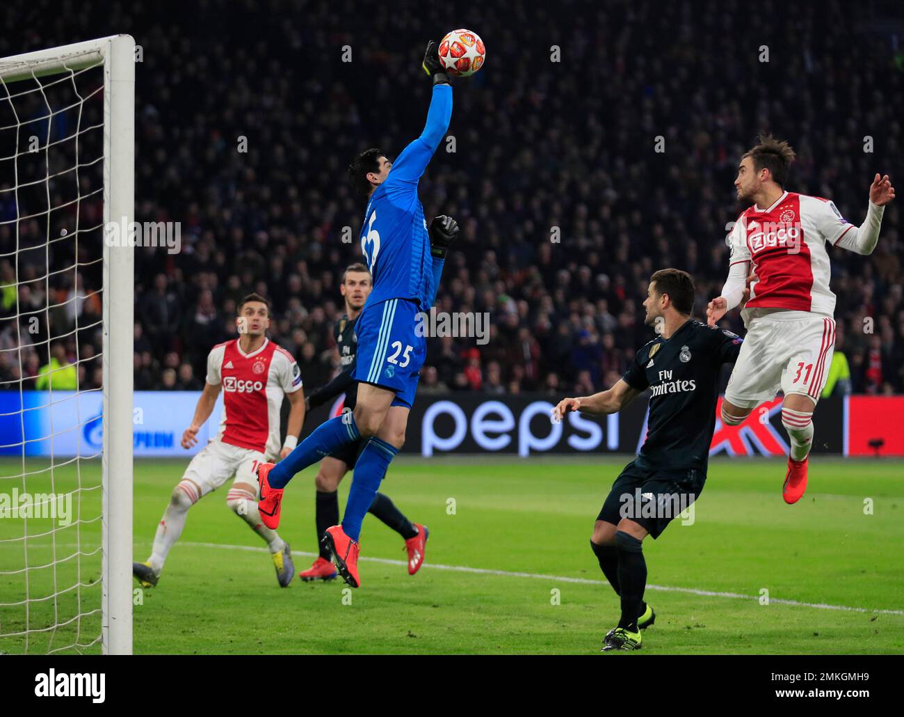 Real goalkeeper Thibaut Courtois makes a save during the first leg ...