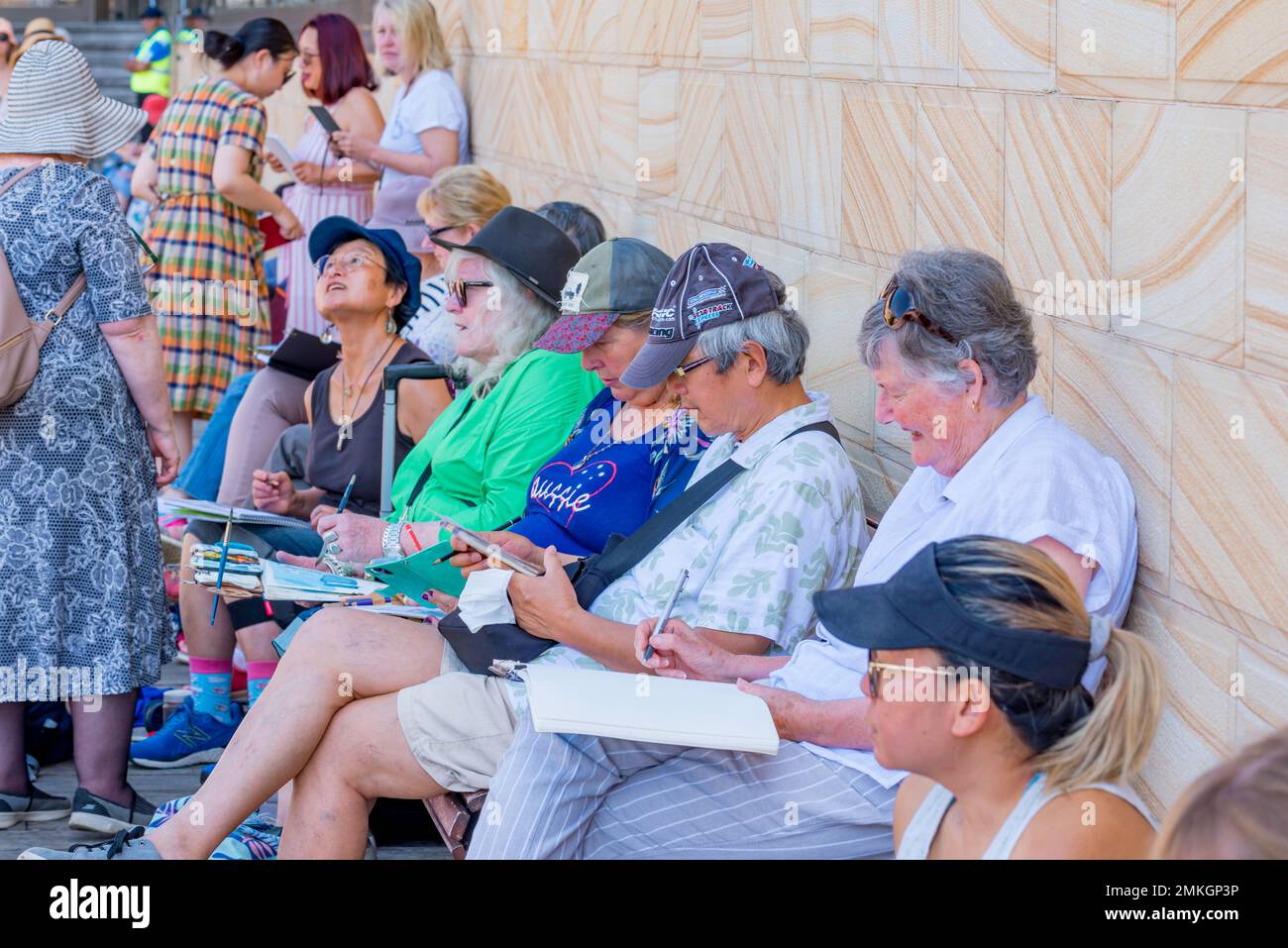 A group of artists (people) sketching and painting during celebrations ...