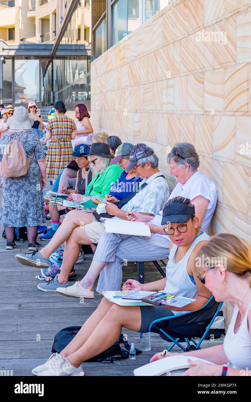 A group of artists (people) sketching and painting during celebrations ...