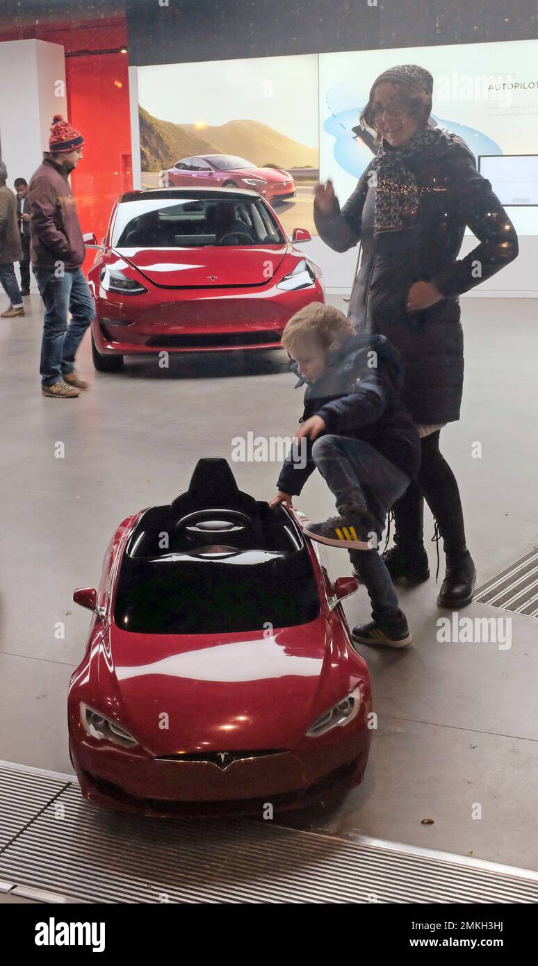 In this Nov. 10, 2018 photo, a child climbs into Tesla Model S, a ...