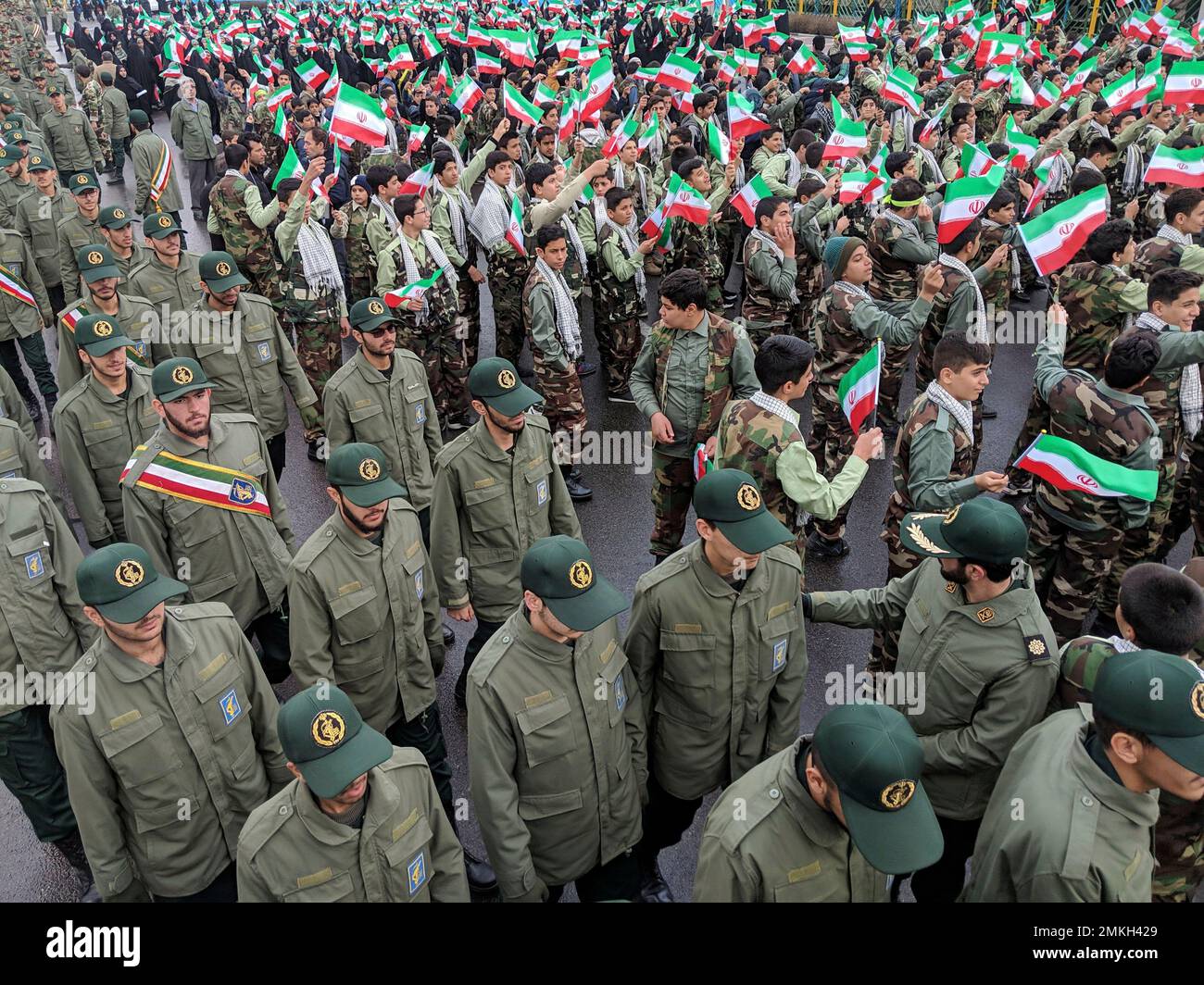 School students wave their national flags as Revolutionary Guard ...