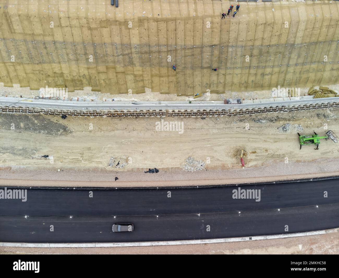 Mountain road constraction. Workers reinforce the slope over the new ...