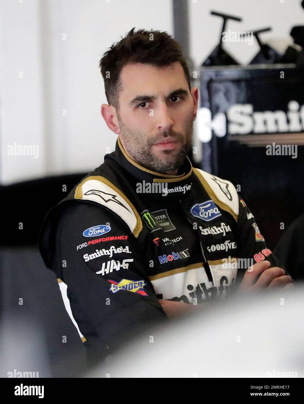 Aric Almirola looks over his car in his garage after NASCAR auto race ...