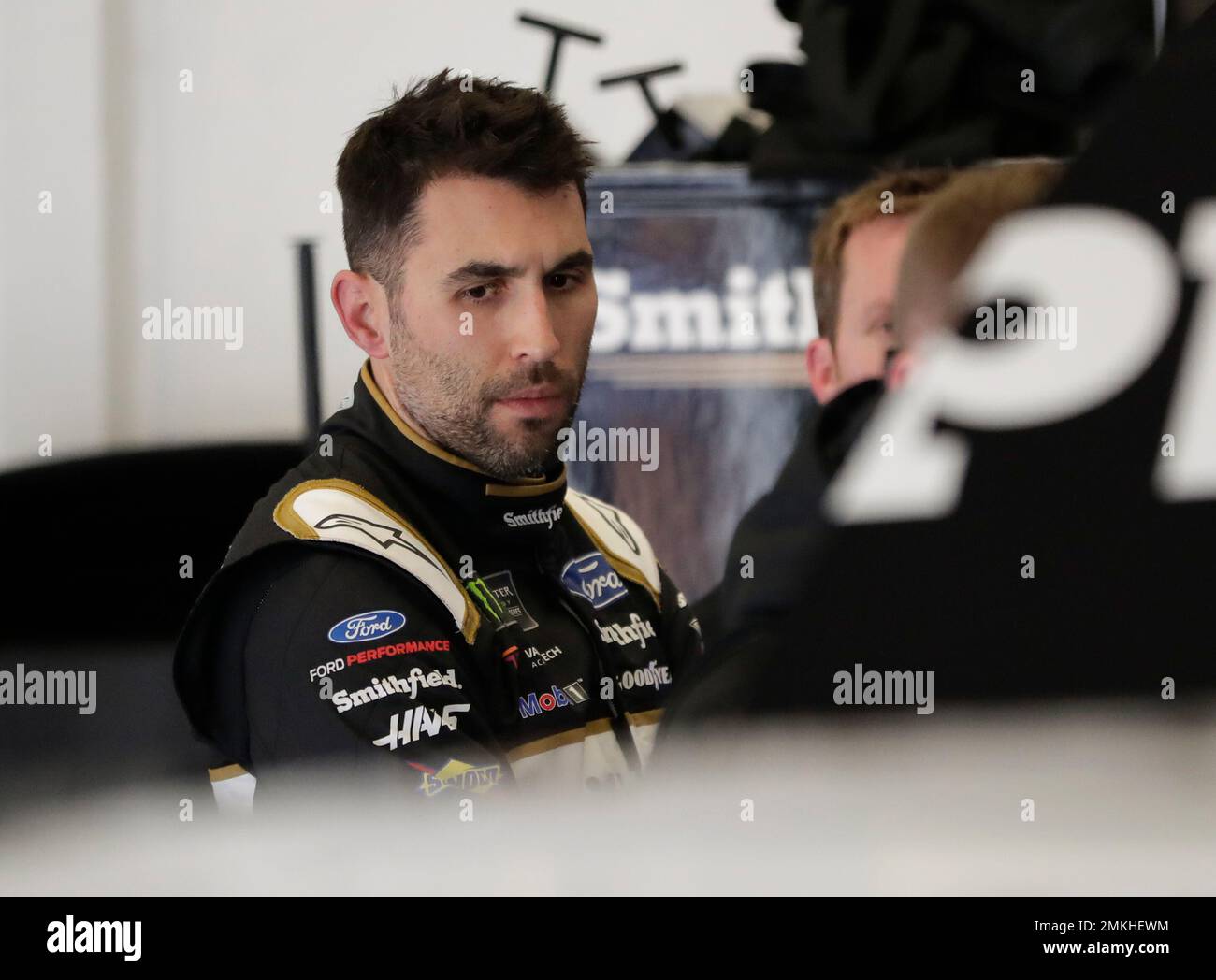 Aric Almirola looks over his car in his garage after NASCAR auto race ...