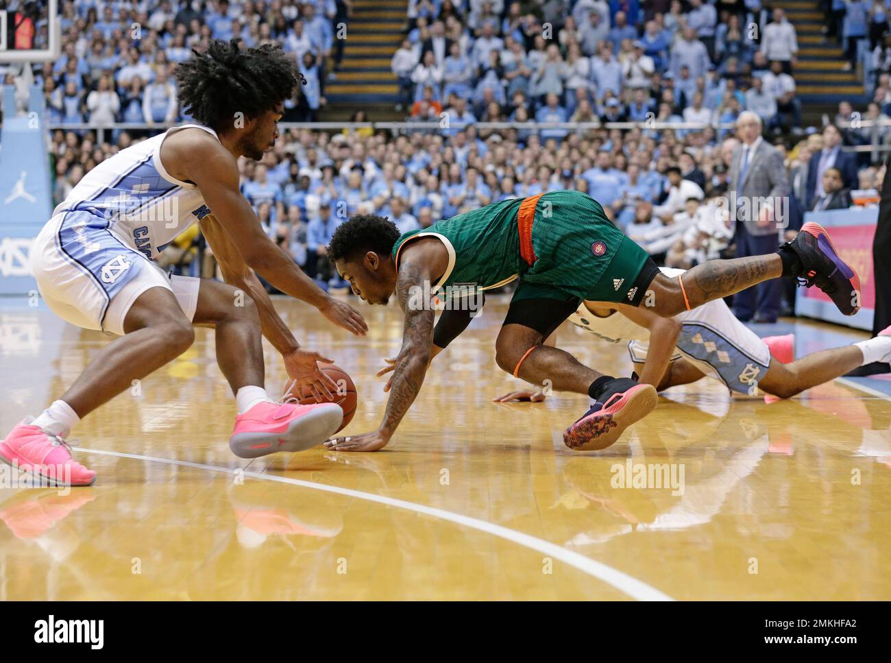 North Carolina's Coby White, left, and Miami's Chris Lykes chase a ...