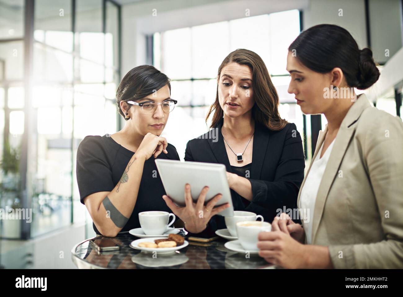 Take a look and tell me what you think. three businesswoman looking at ...
