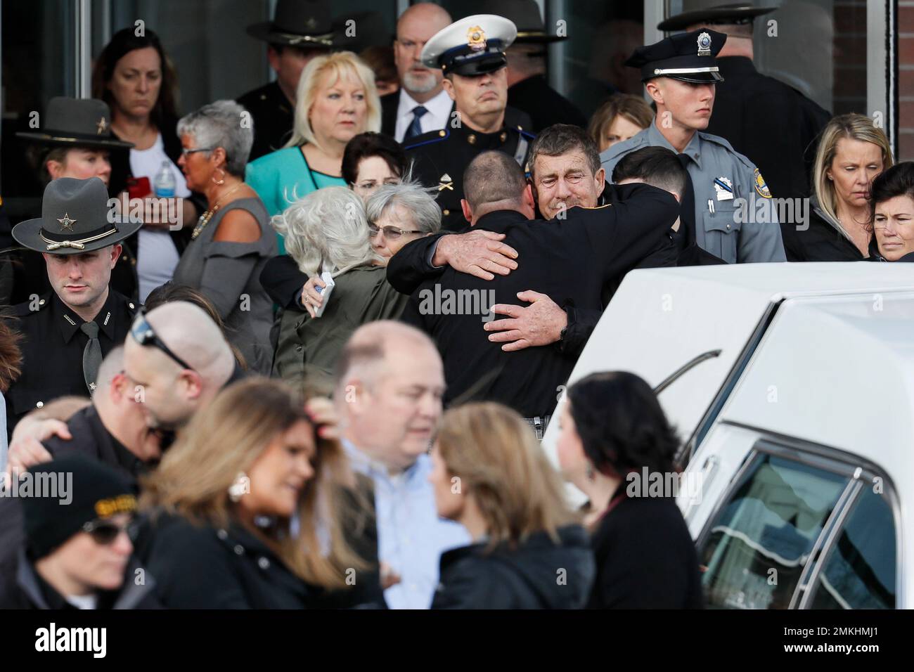 Officers and mourners react after the casket of Detective Bill Brewer ...