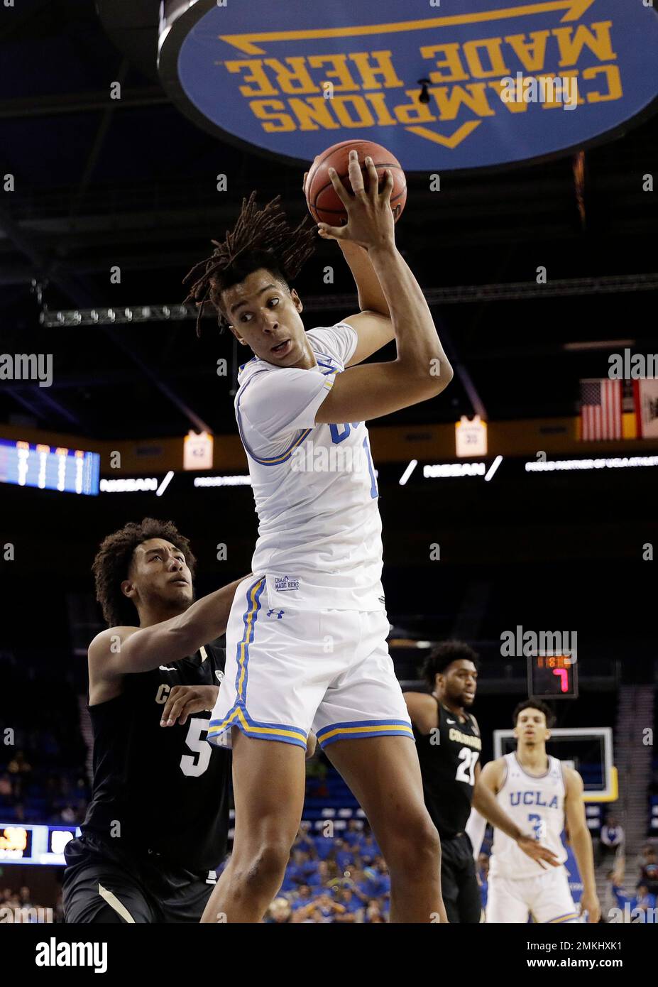 UCLA center Moses Brown, center, grabs a high pass as Colorado guard D ...