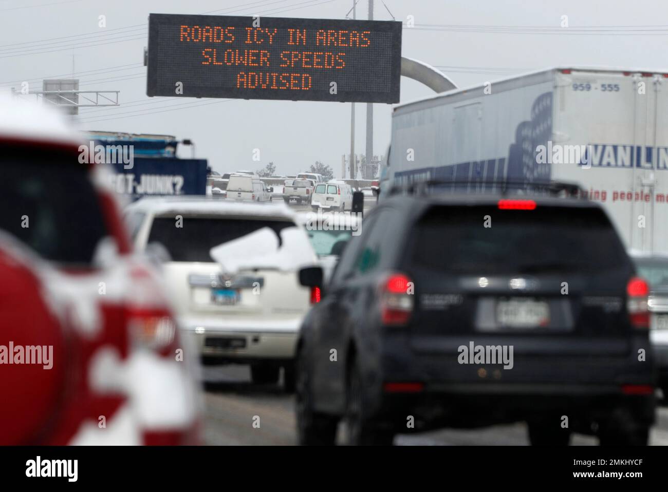 An overhead sign warns motorists of dangerous conditions as traffic ...