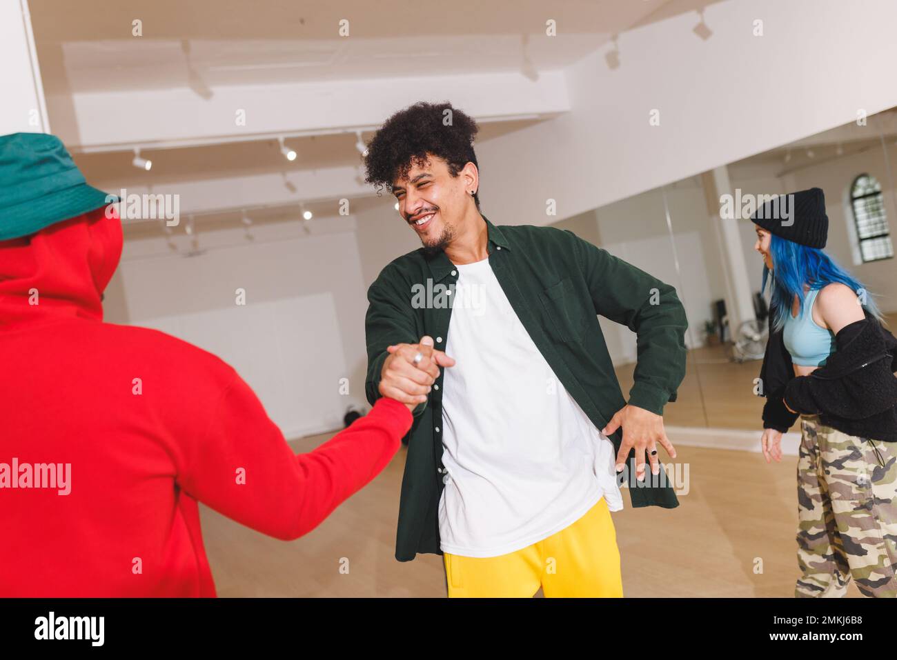 Image of happy diverse male hip hip dancers shaking hands in studio ...