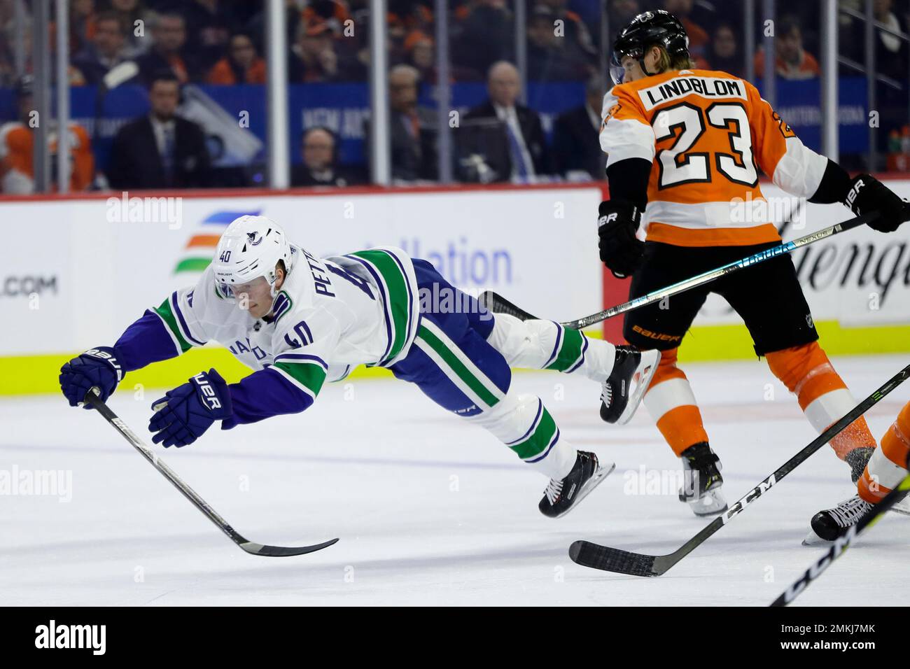 Vancouver Canucks' Elias Pettersson (40) gets tripped by Philadelphia Flyers' Oskar Lindblom (23 ...