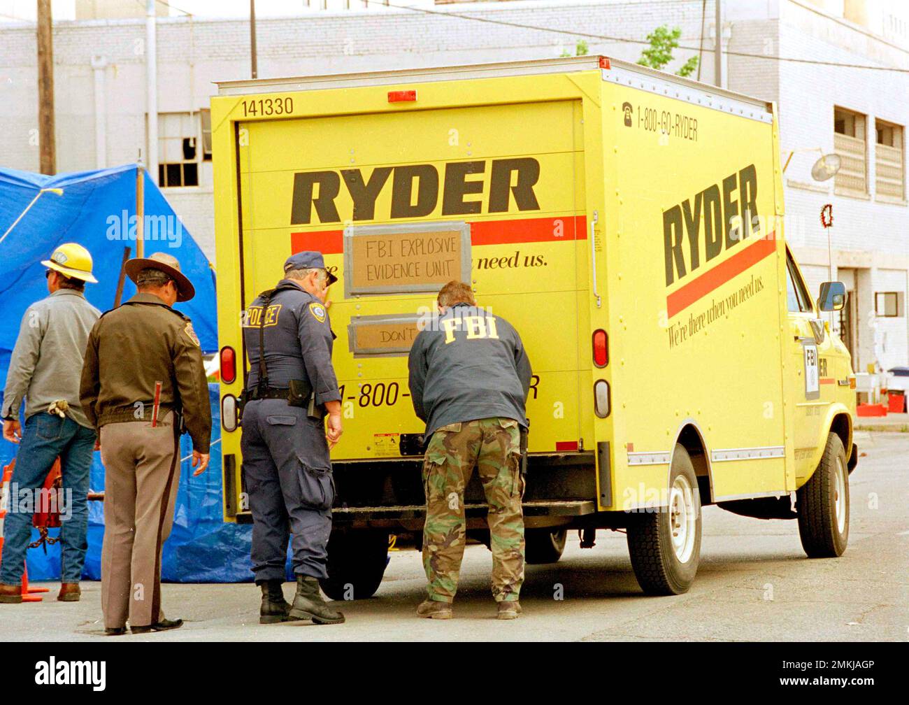 An FBI agent, right, opens the back door of a Ryder truck for guards ...
