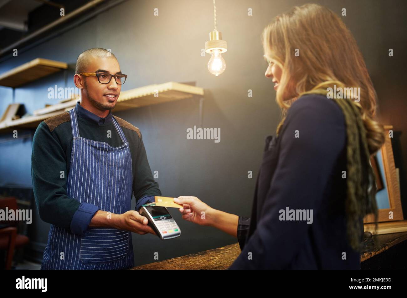 The easiest way to pay. a customer paying using NFC technology in a ...