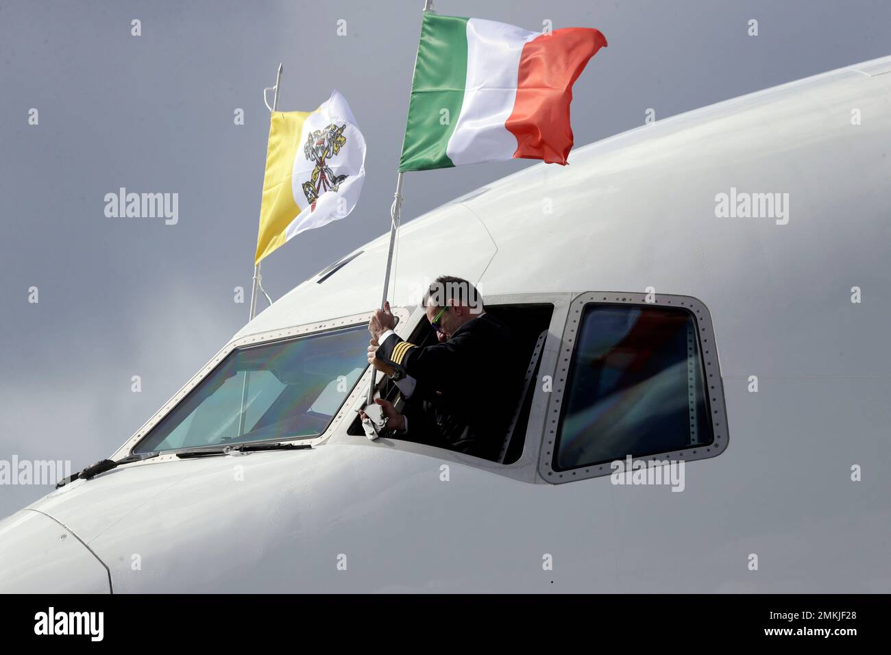 An Alitalia pilot set the Italian flag beside the Vatican flag outside ...