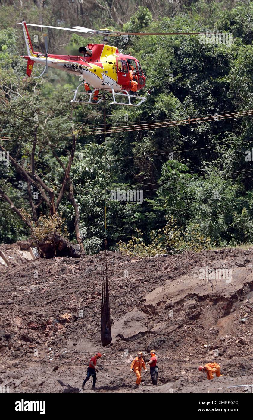 A helicopter lifts a body that was recovered from the mud days after a ...