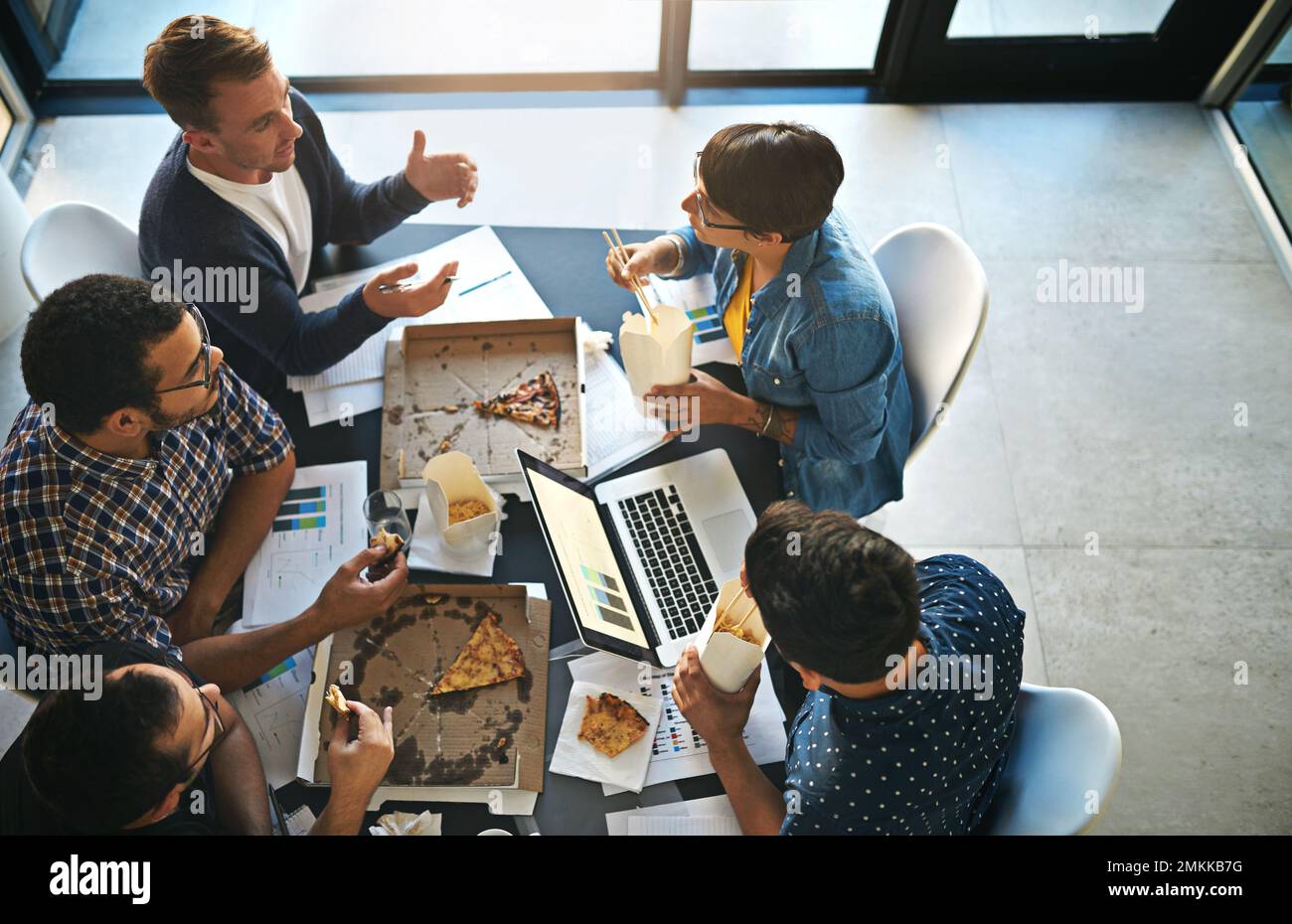 Meeting over a meal. a group of colleagues eating while having a ...