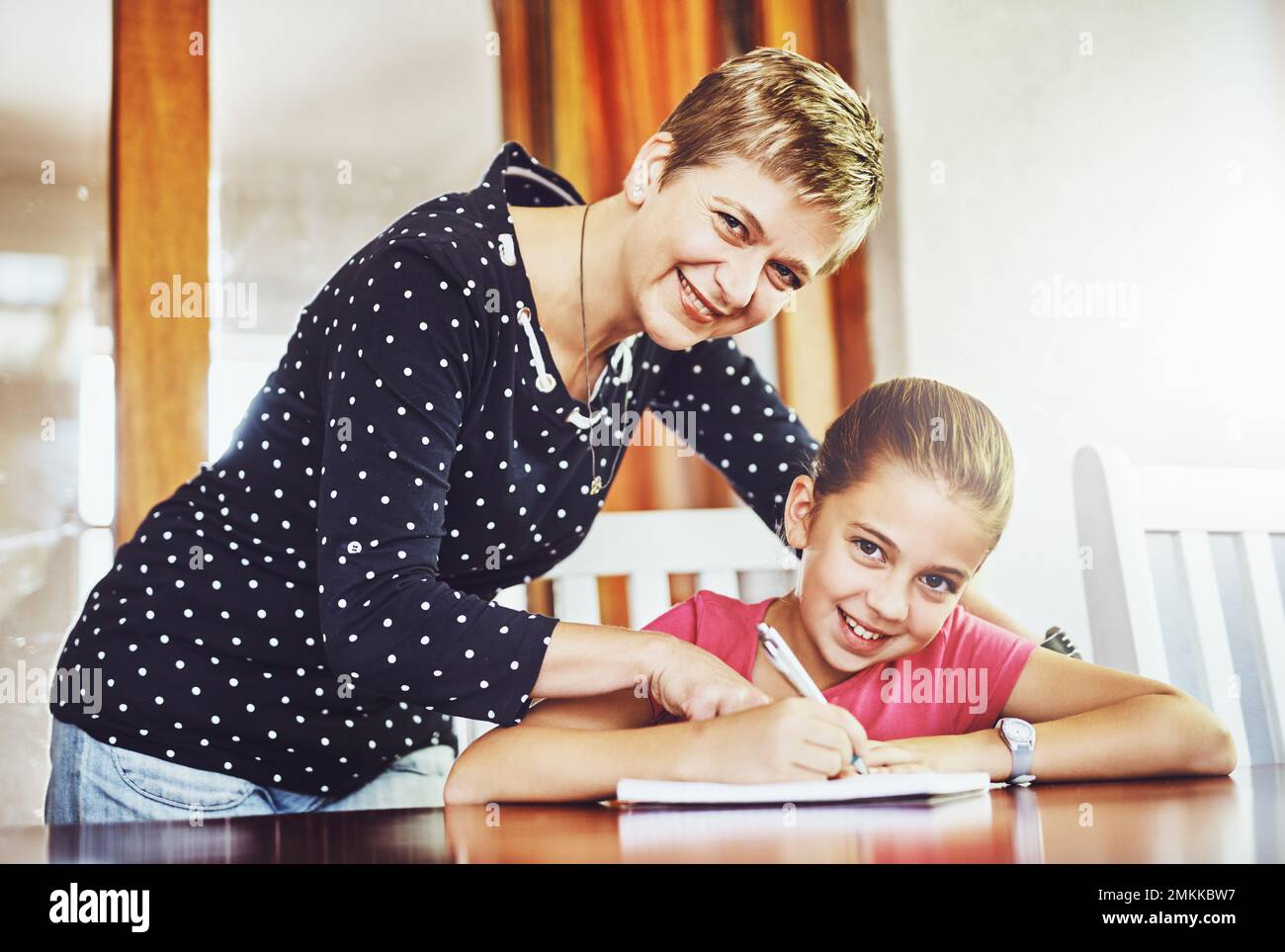 Happy to help my child with homework. Portrait of a cheerful mother and ...