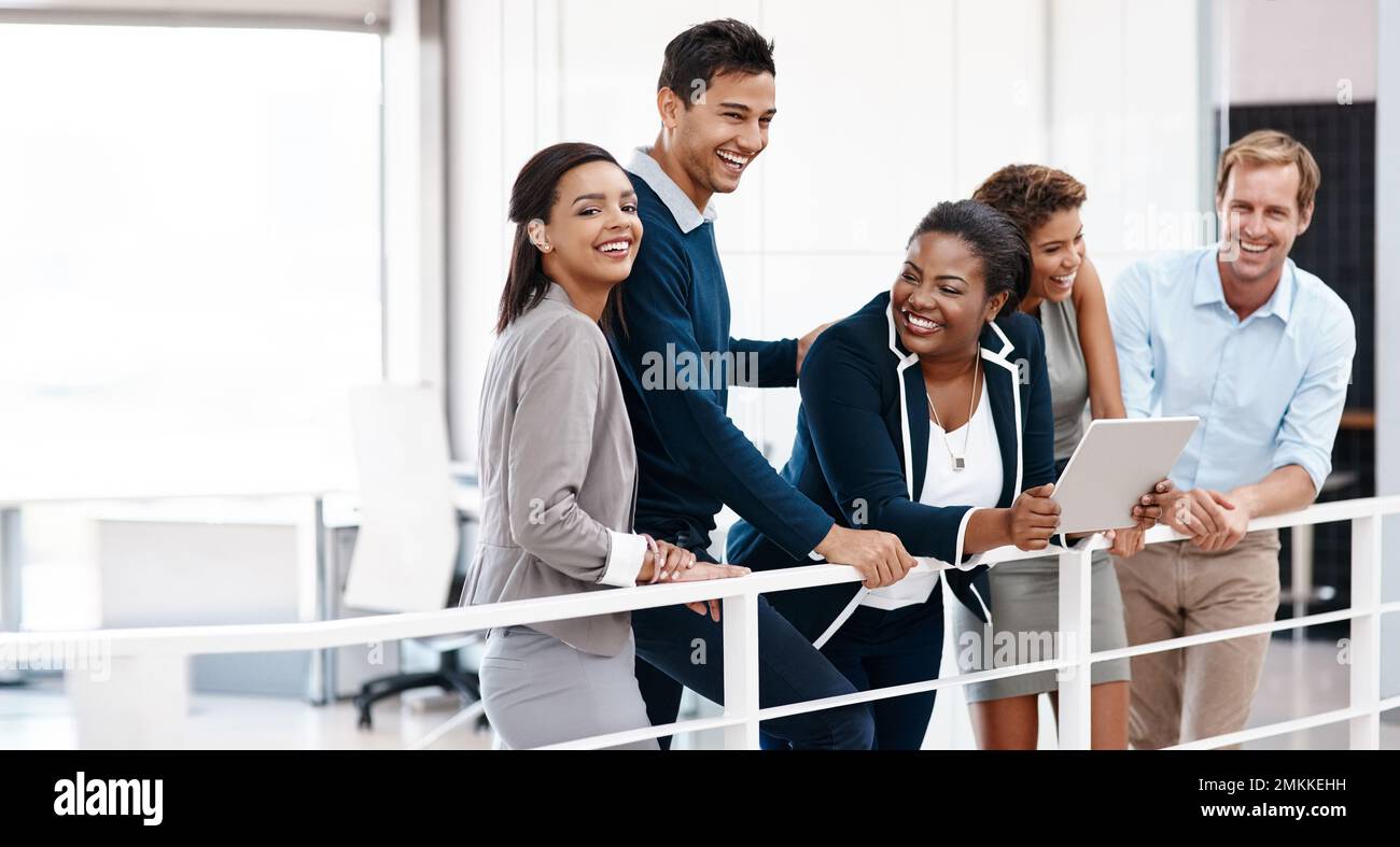 We can still enjoy a laugh at work. a happy group of colleagues sharing a laugh together in the ...