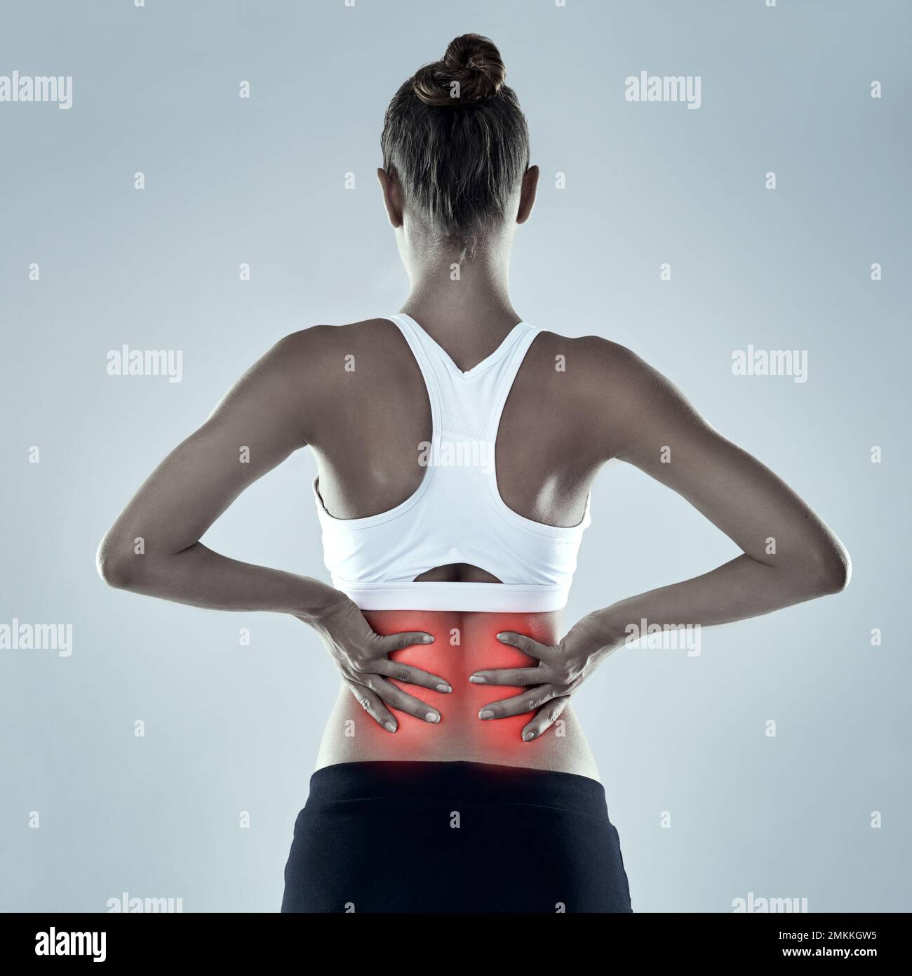 Feeling a little pain in her lower back. Studio shot of an athletic ...