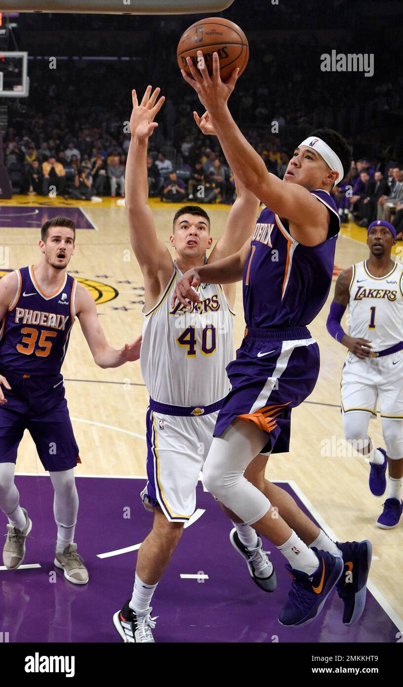 Phoenix Suns guard Devin Booker, second from right, shoots as Los ...