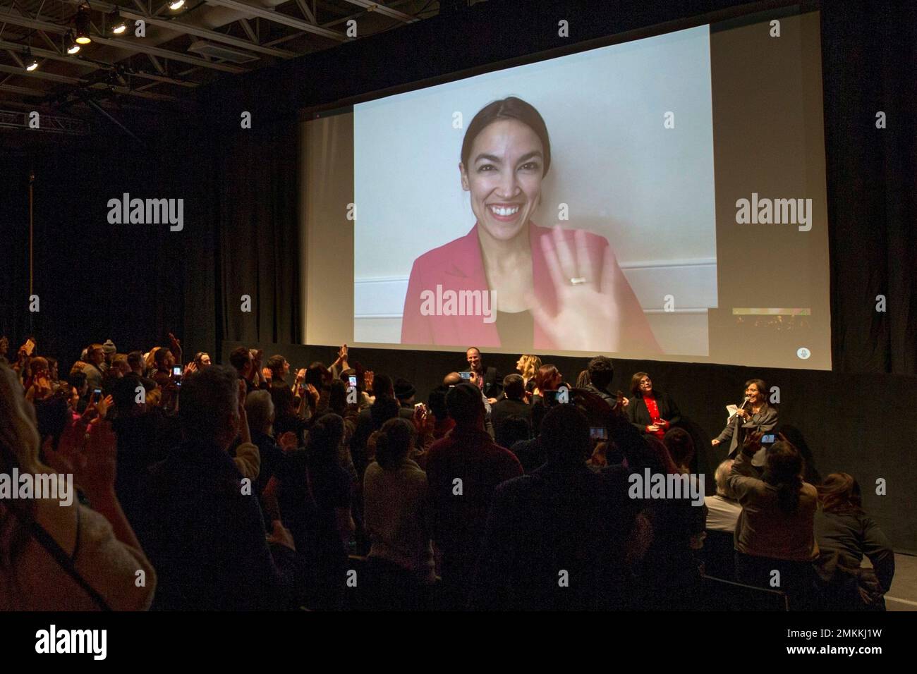Rep. Alexandria Ocasio-Cortez, D-N.Y. waves as she appears over video ...