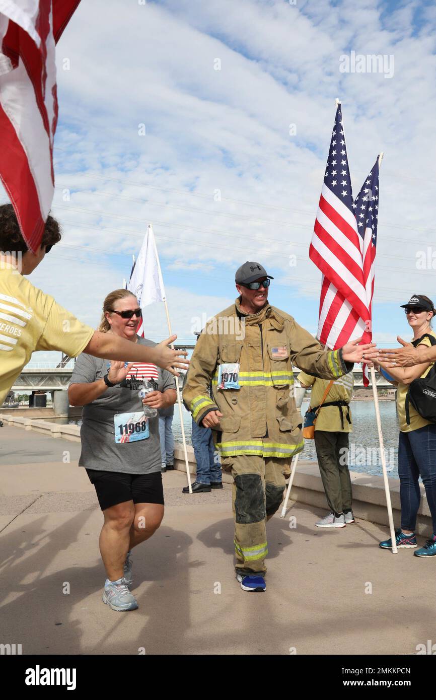 A volunteer runner wearing a fire fighting suit is cheered on at the ...
