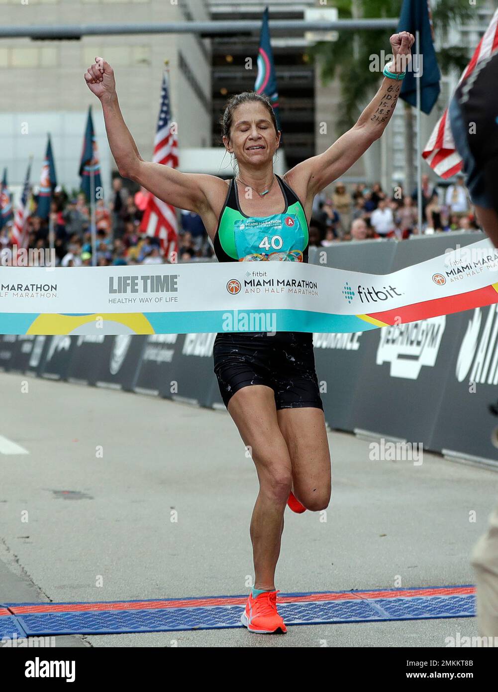Kate Landau, of Tacoma, Washington, crosses the finish line to win the ...