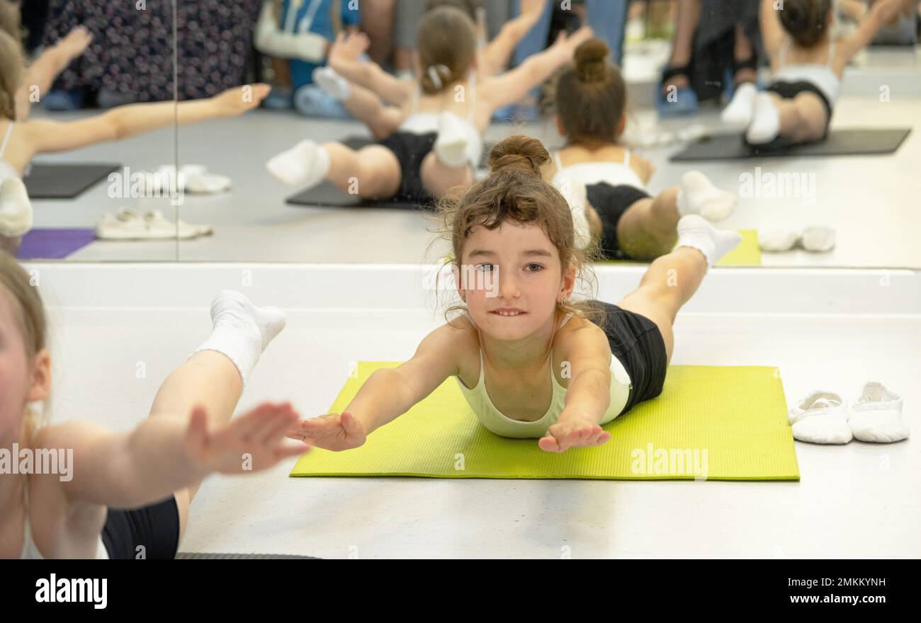 Child trains in gym on the mat, does stretching exercises and abs ...
