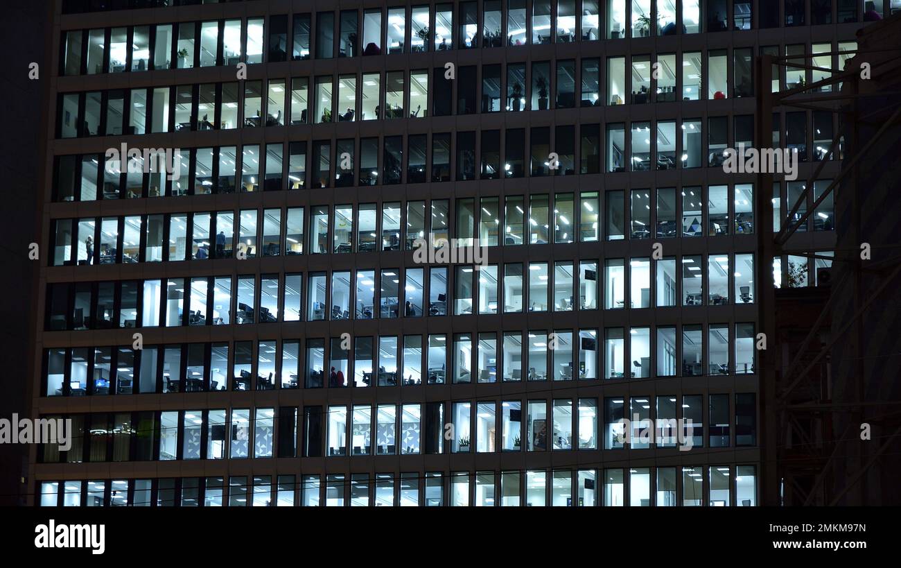 Pattern of office buildings windows illuminated at night. Glass ...