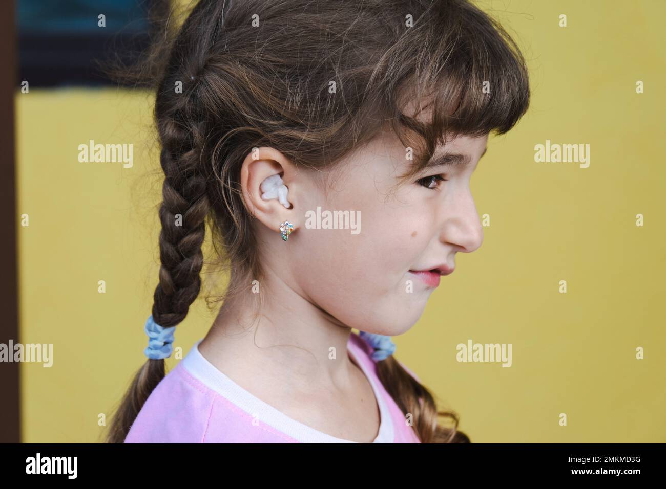 Girl with a warming therapeutic cotton swab in the ear with a sad and ...