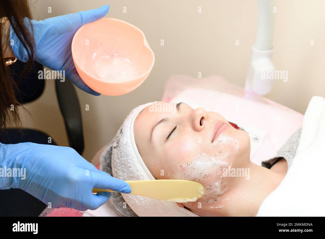 The process of applying a moisturizing mask to the face in a spa salon ...