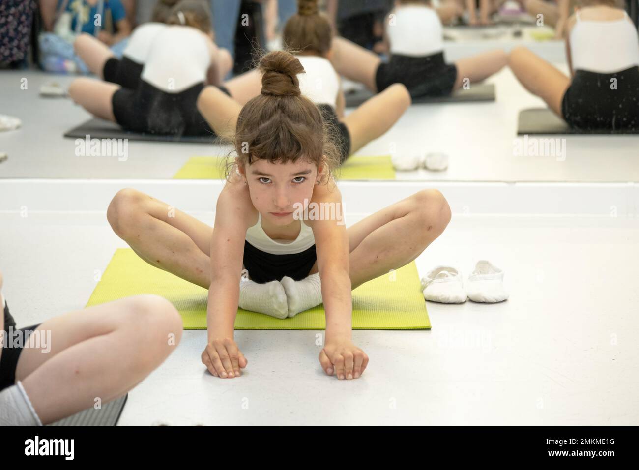 Child trains in gym on the mat, does stretching exercises and abs ...